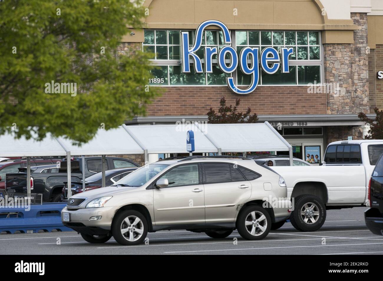 A logo sign outside of a Kroger retail grocery store location in ...