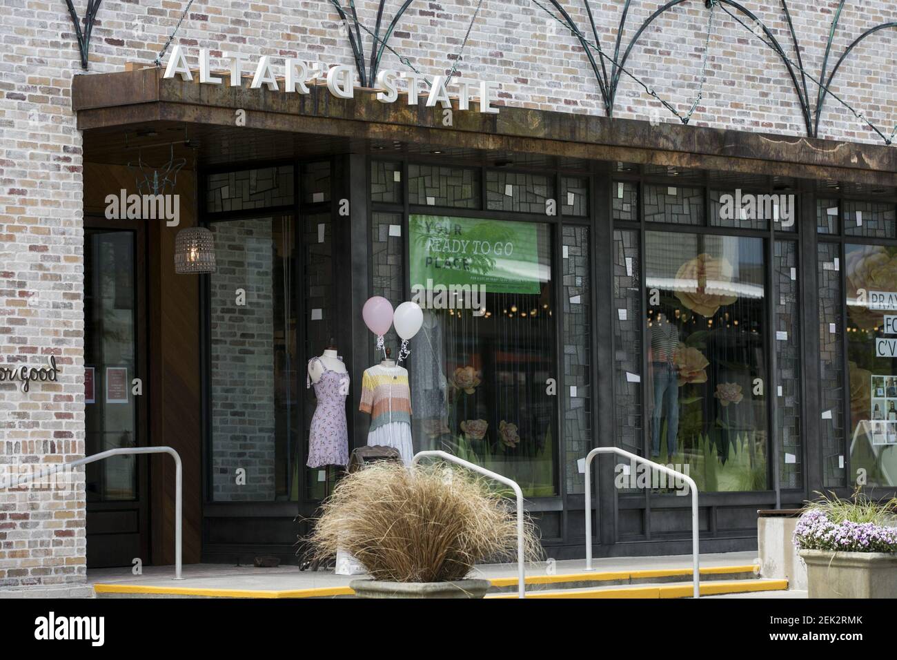 A logo sign outside of a Altar'd State retail store location in ...