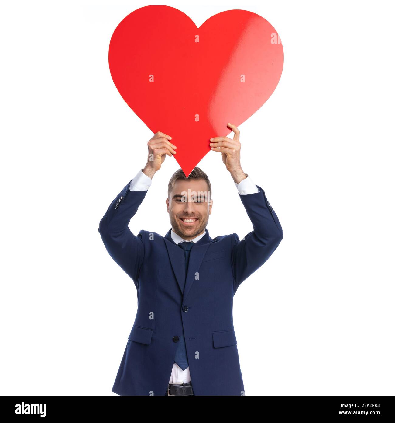 happy young man in elegant navy blue suit on white background holding ...