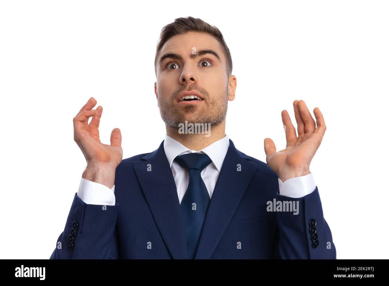 surprised unshaved man in navy blue suit looking up and shockingly hand ...