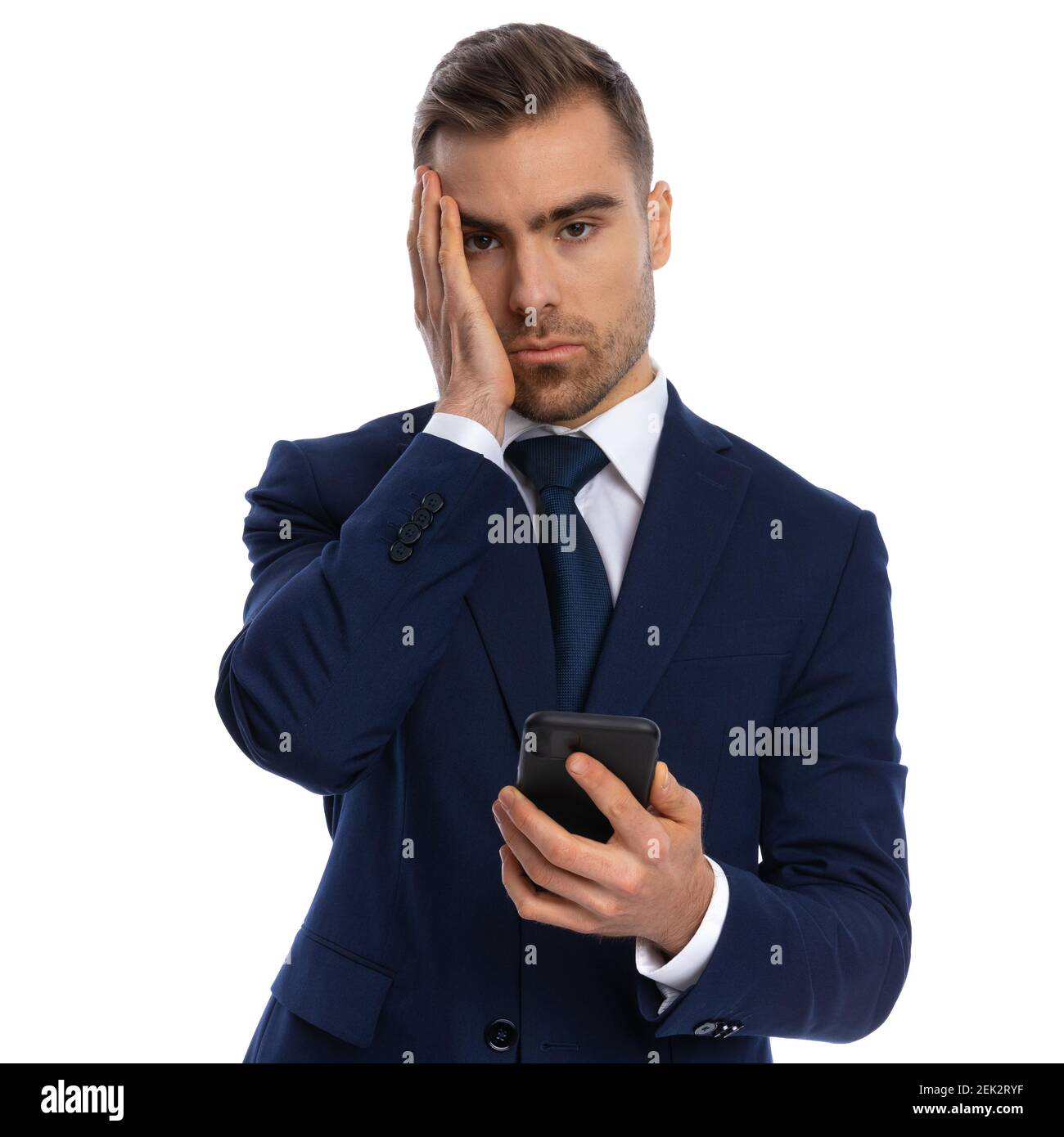 upset young businessman in navy blue suit holding phone and face ...