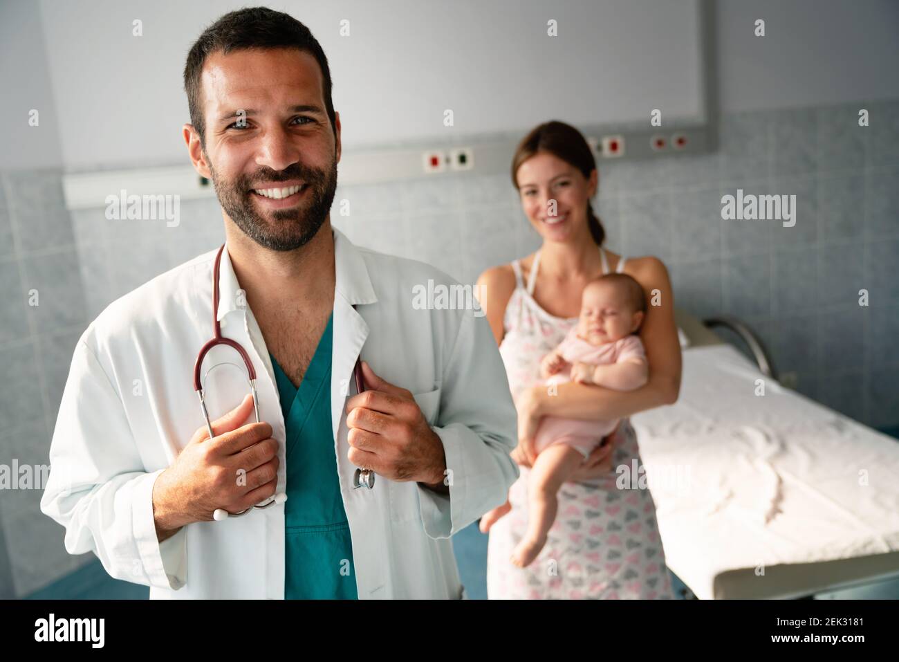 Pediatrician doctor medical examining little smiling baby, held by ...