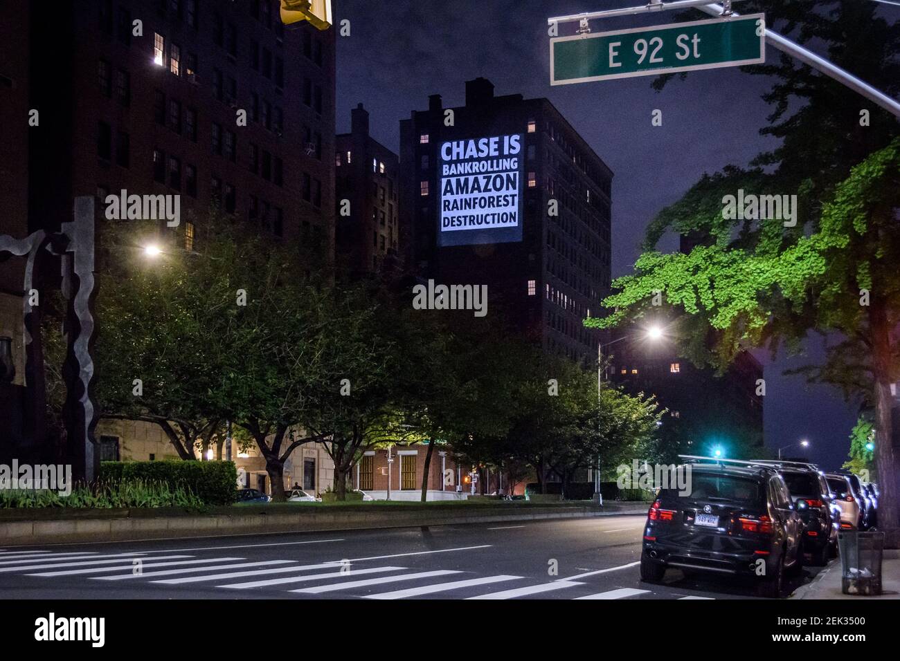 Stop the Money Pipeline projecting messages on a building wall across ...
