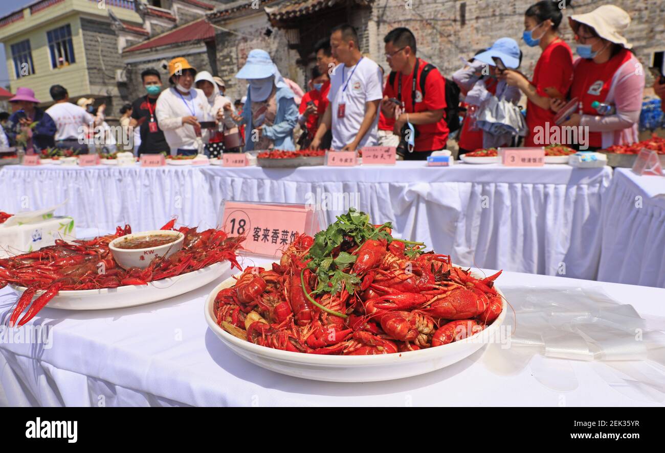 People take pictures of the crayfish dishes presented at the Second ...