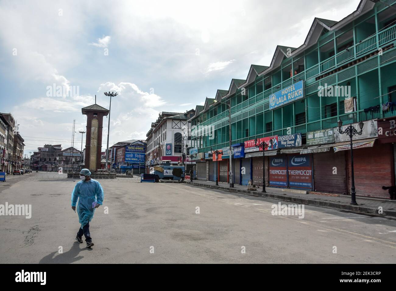 A man wearing a Personal Protective Equipment (PPE) walks along the ...