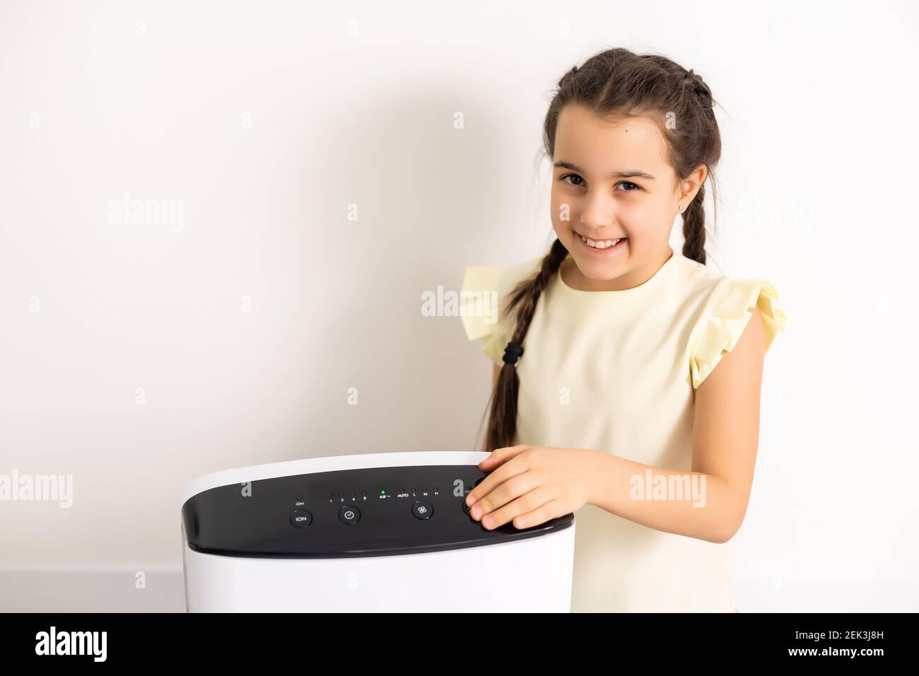 Primary school age girl enjoy comfort at home with air humidifier white ...