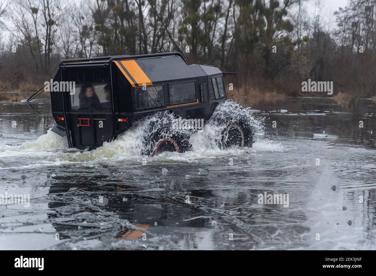 Off-road vehicle with passengers crossing an icy river Stock Photo - Alamy