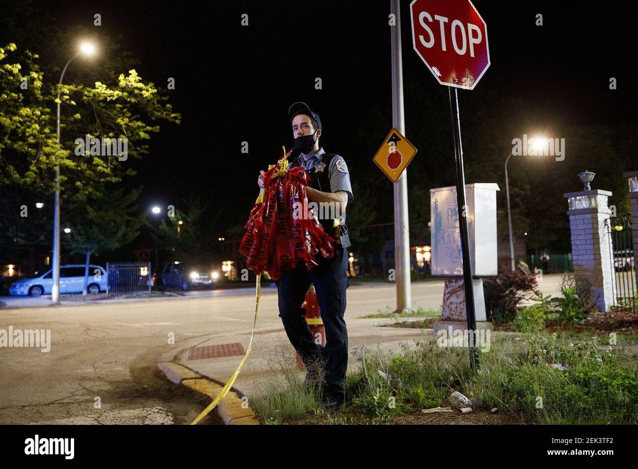 A Chicago police officer collects police tape shortly after midnight ...