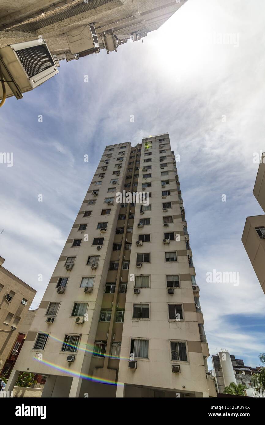 Vertical low angle shot of a building under blue sky and white clouds Stock Photo - Alamy