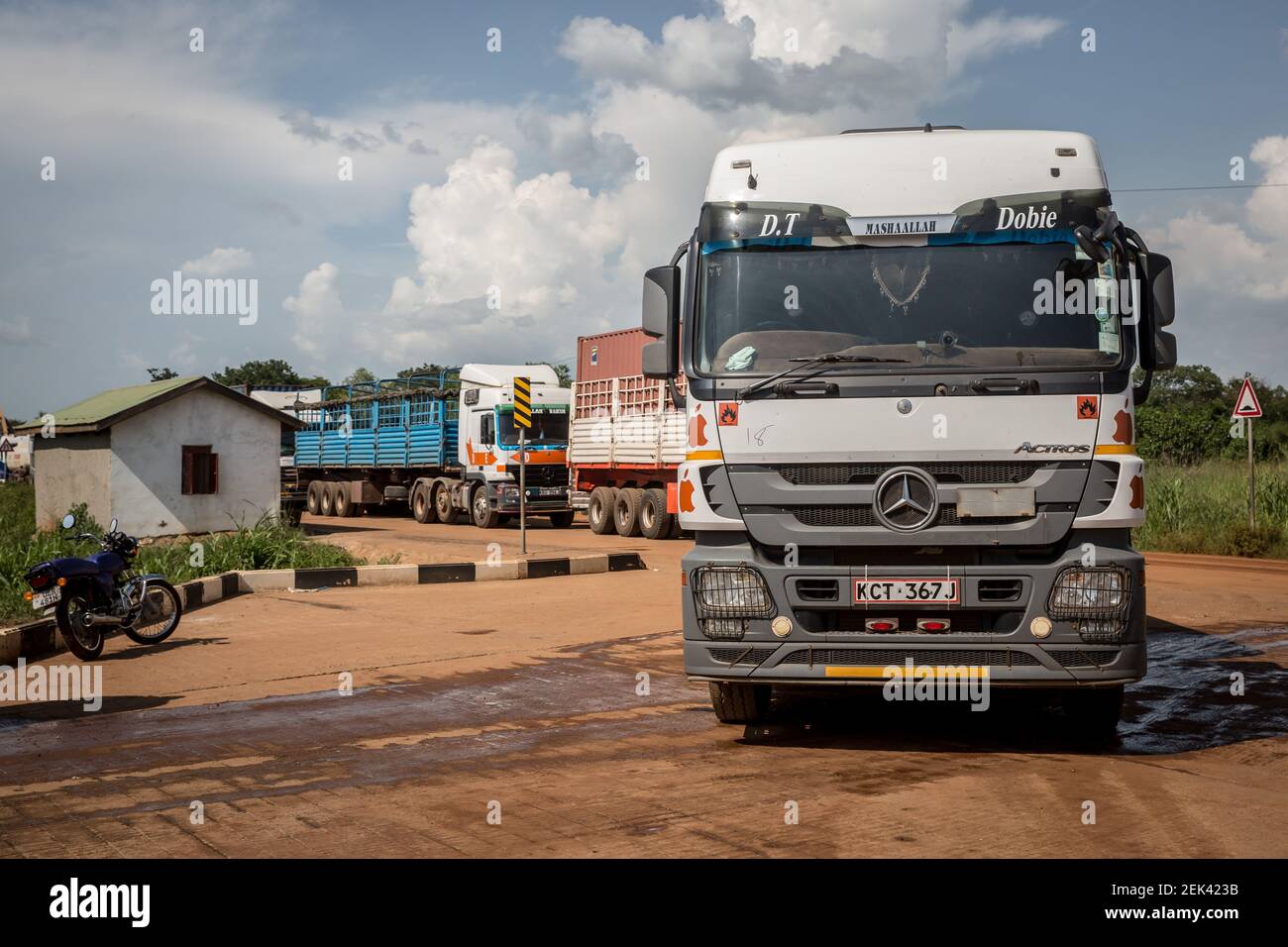 Trucks line up before a checkpoint at the Elegu border point between ...