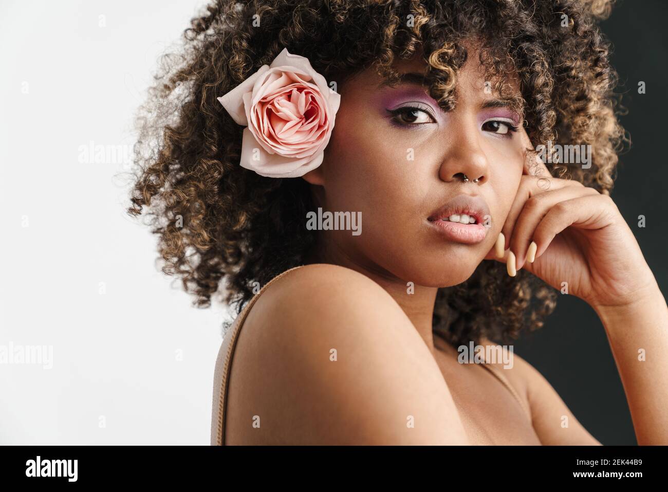 Beautiful sensual african american girl with rose posing at camera isolated over white ...