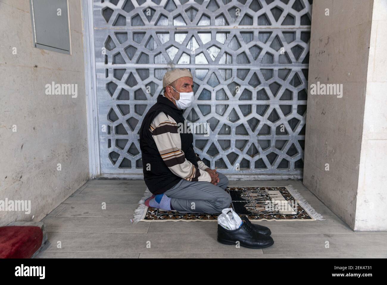People wearing face masks perform Friday prayer, following the social ...