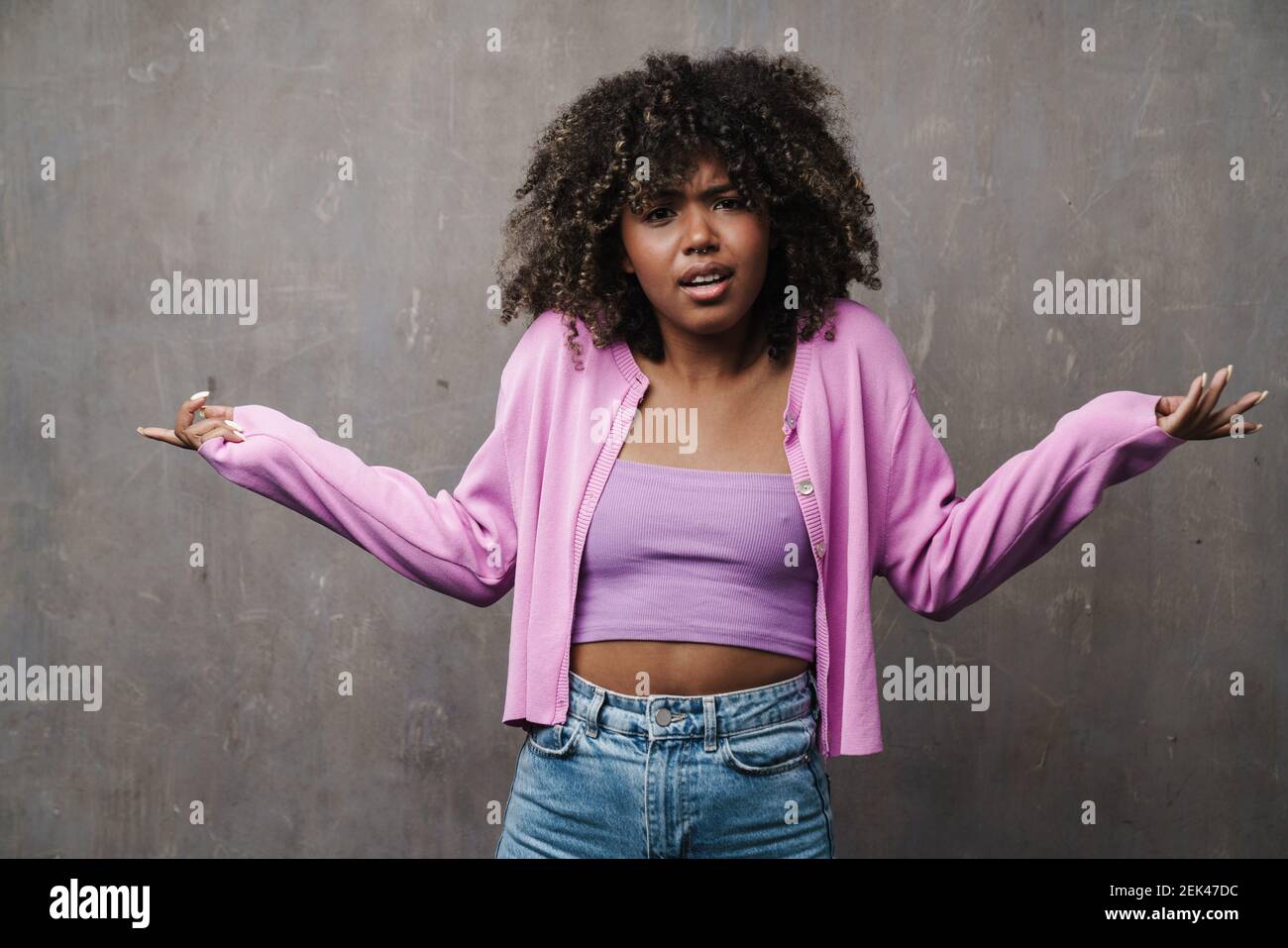 Confused african american woman posing and holding copyspace isolated ...