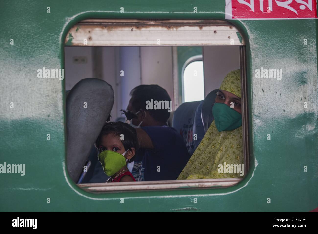 Passengers wearing face masks as a preventive measure sit in a train ...