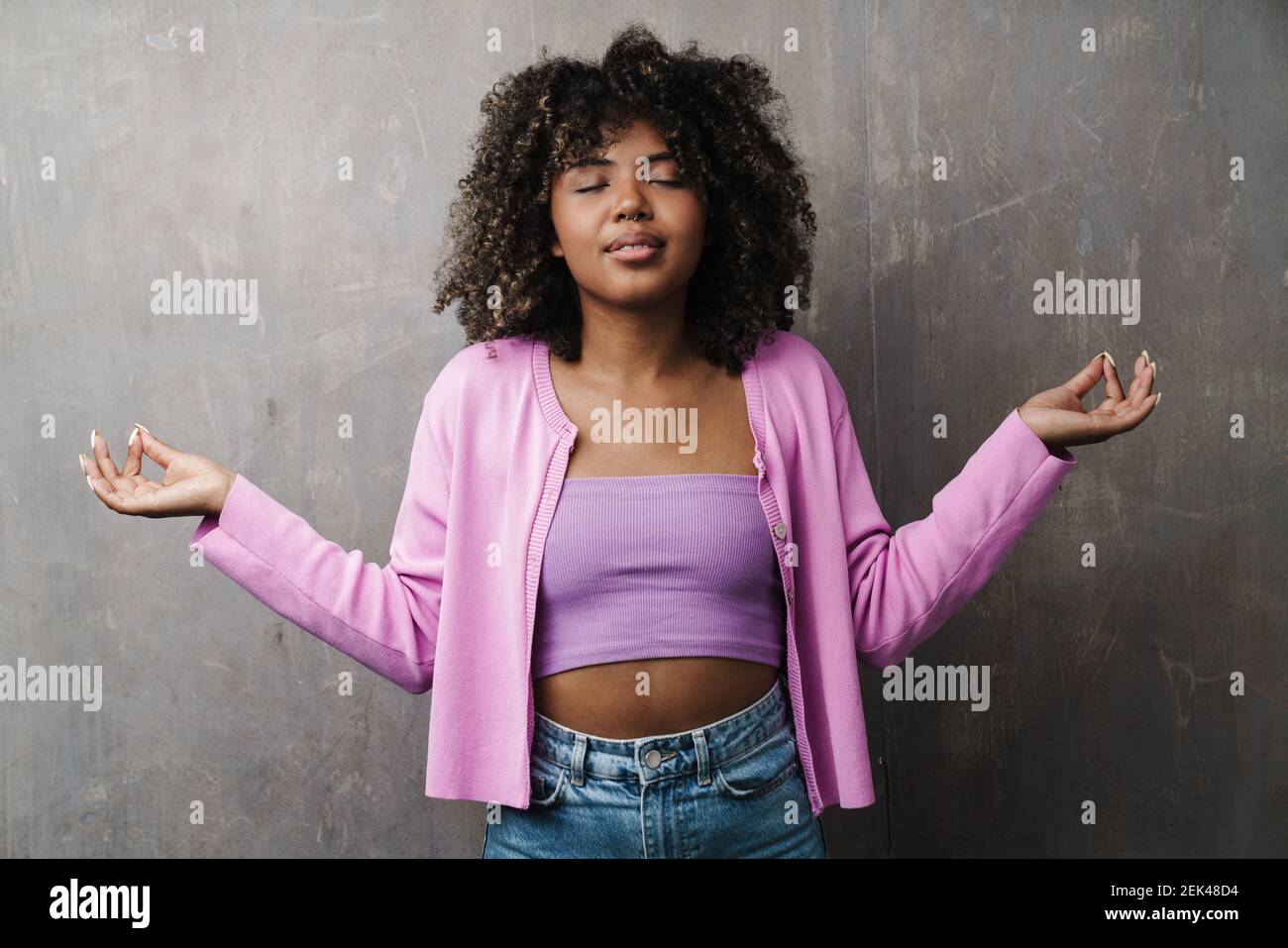 Relaxed african american woman meditating with fingers together ...