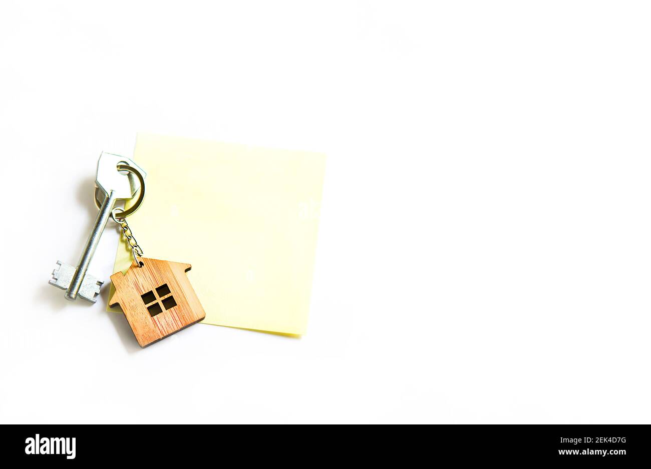 Keychain in the shape of wooden house with key on a white background ...