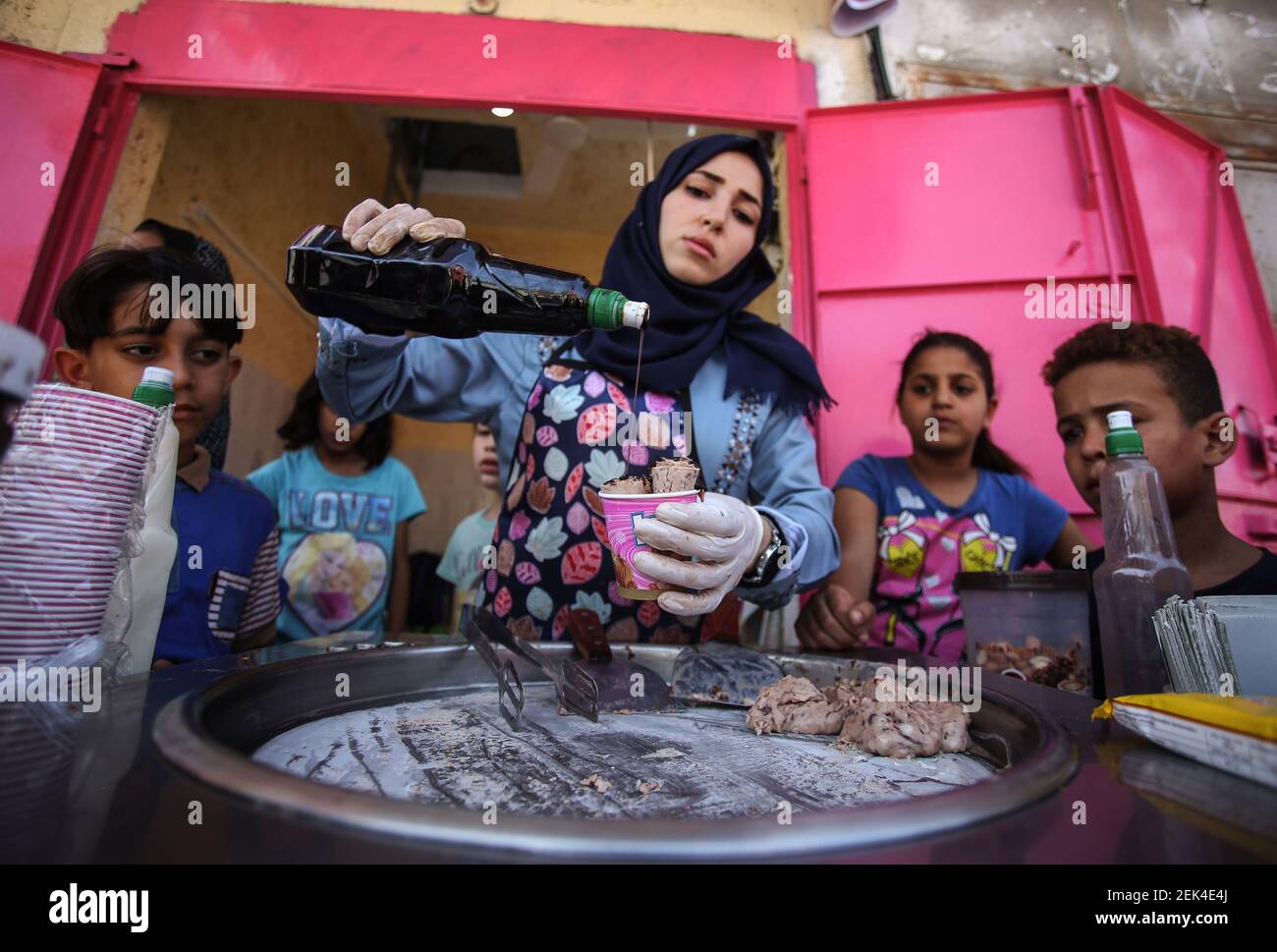 A Palestinian woman, Fatima Al-Zatma, 24, adds a flavour in the ice ...