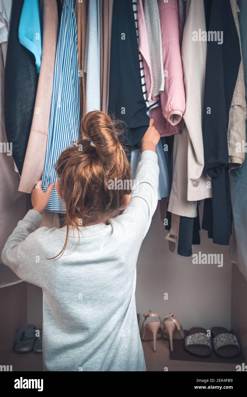 A cute little girl opened the closet. Side view Stock Photo - Alamy