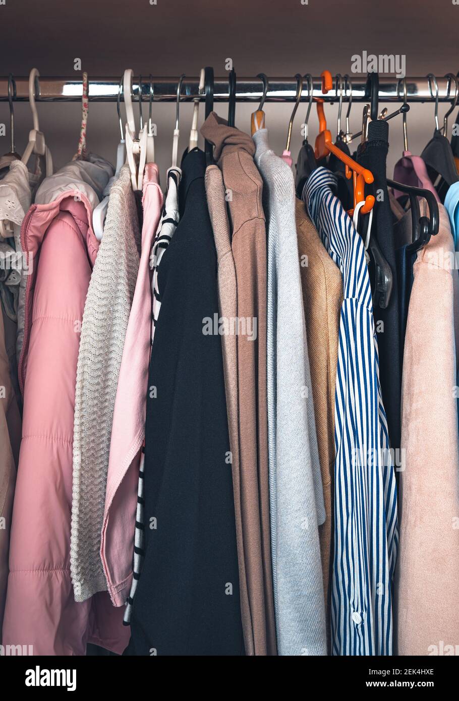 Things on hangers hang in a row. Storage of things. Side view, vertical ...