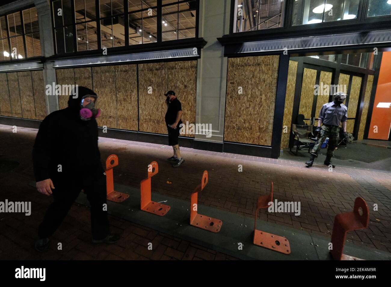 Men guard the Nike store on the fifth night of action against police ...