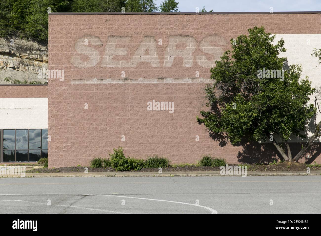 The faded outline of a logo sign outside of a closed and abandoned ...