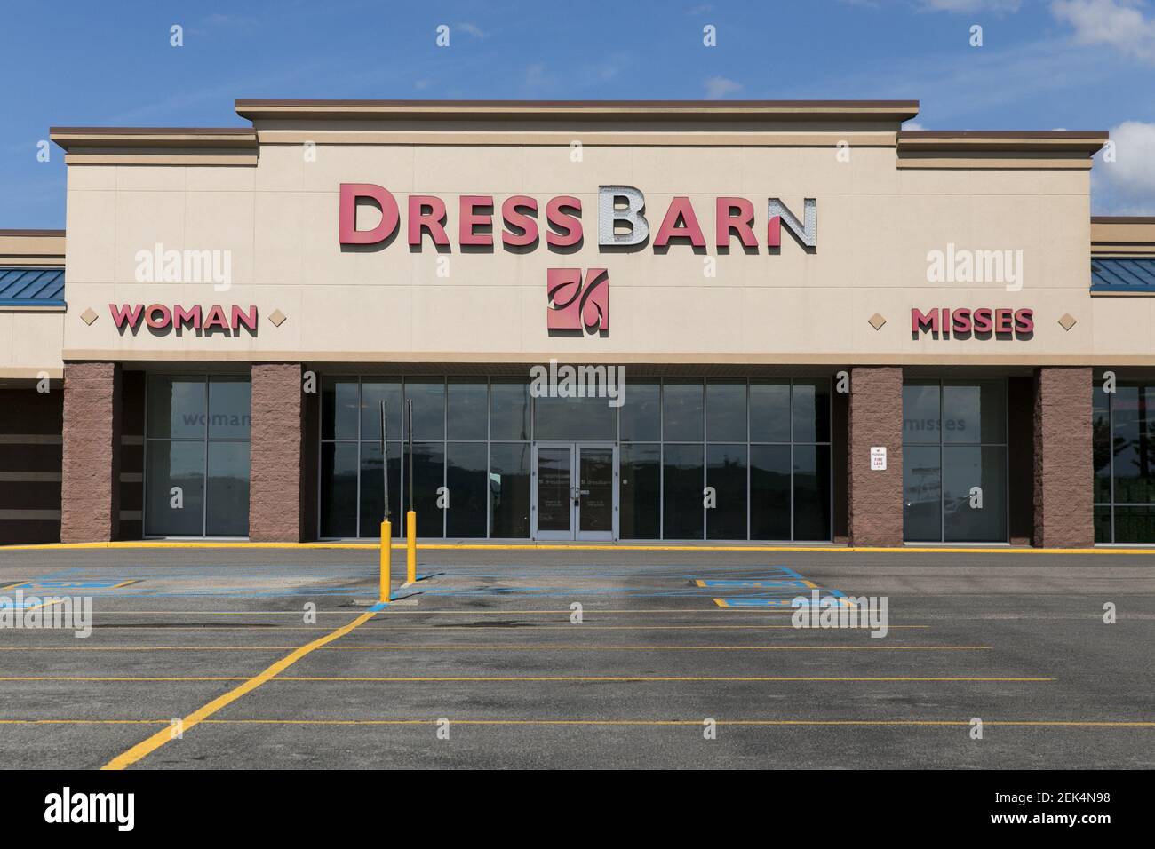 A logo sign outside of a closed and abandoned Dressbarn retail store ...