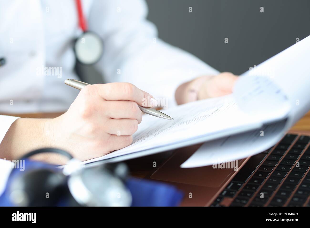 Doctor's hand makes note on medical documents Stock Photo - Alamy