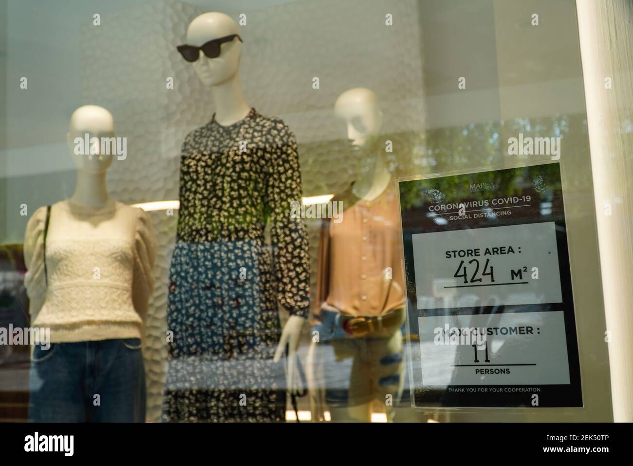 A sign of 11 maximum customer limitation inside a store as a precaution ...