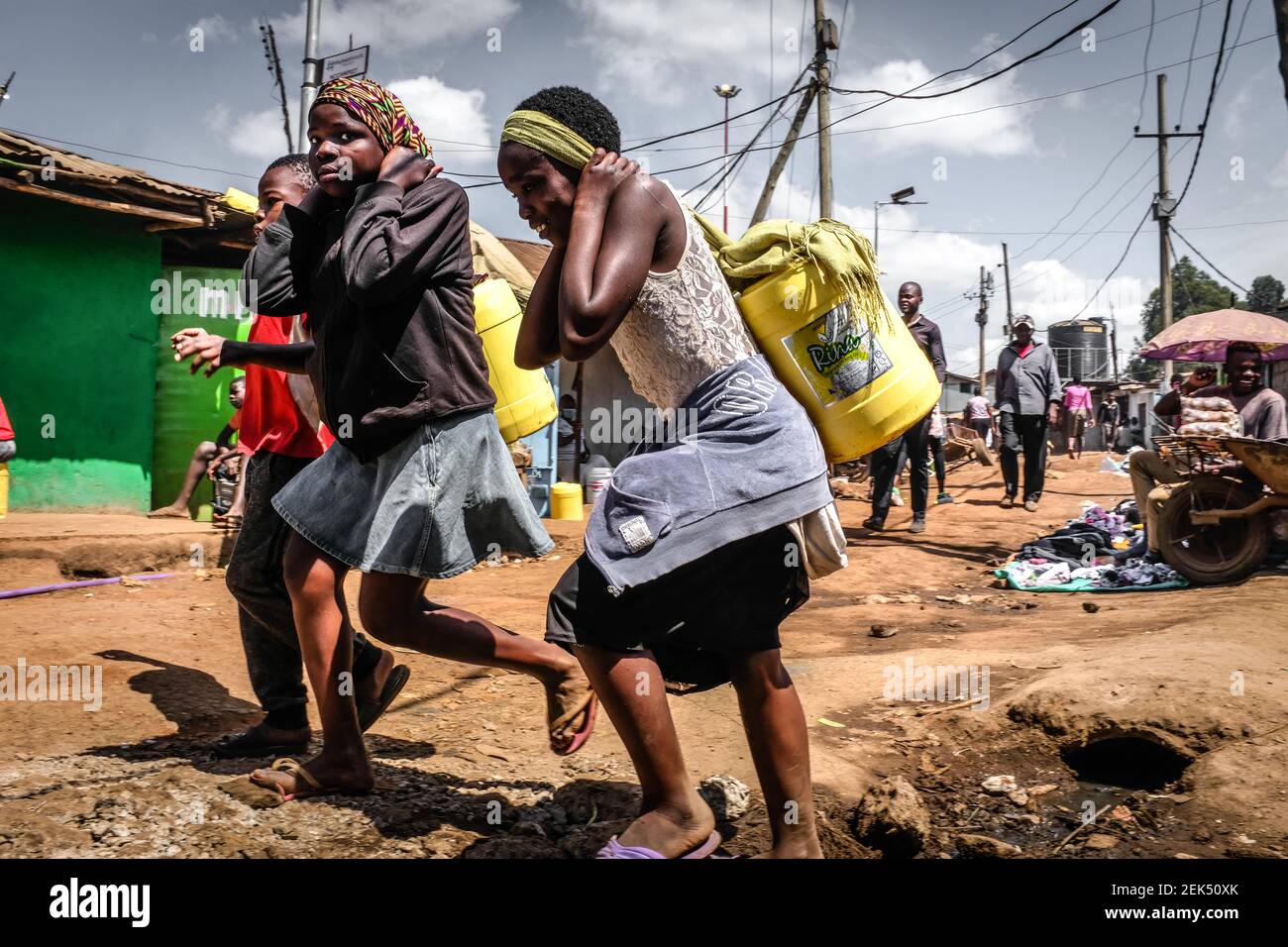 Young girls walk back home while carrying Jerrycans of water amid ...