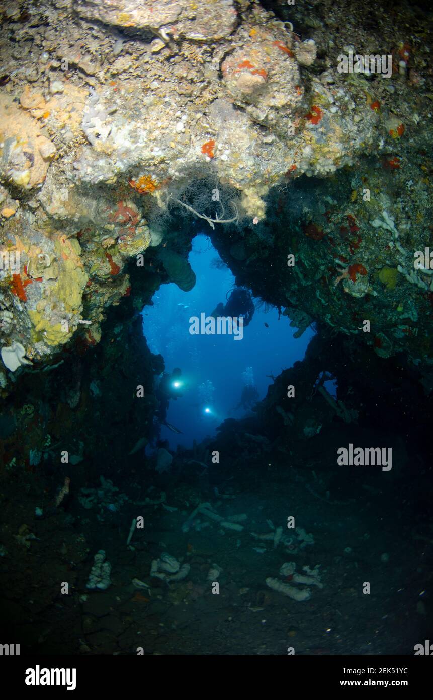 Divers exiting cave, The Cove dive site, Atauro Island, East Timor ...