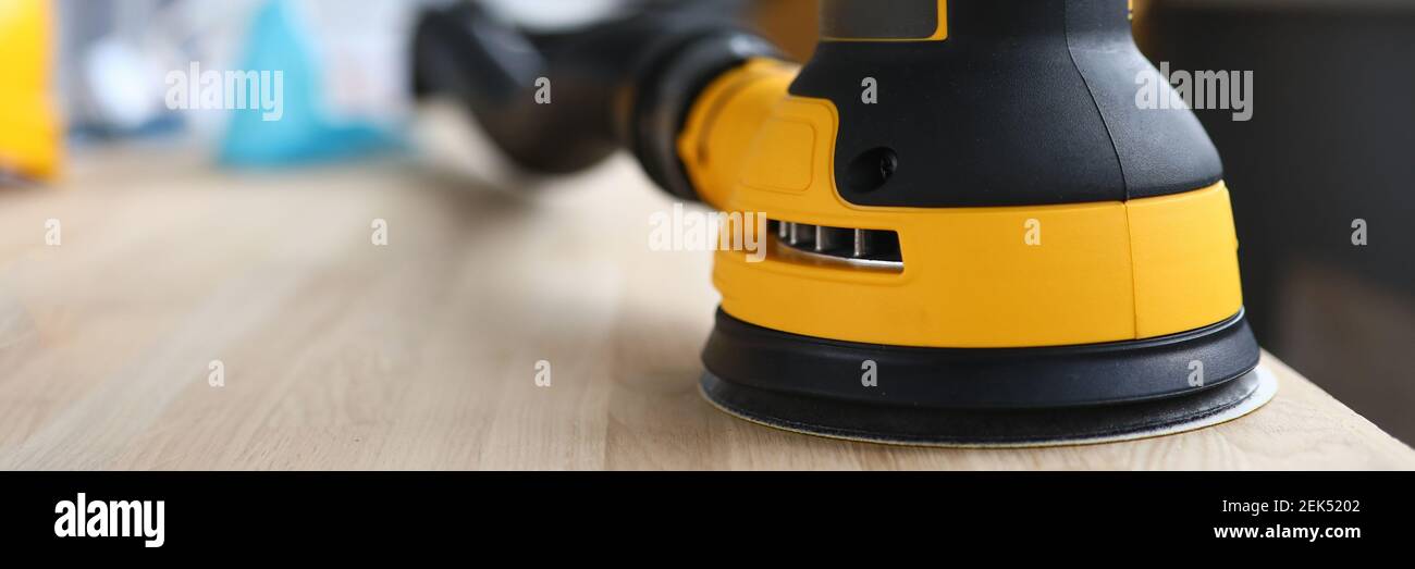 Yellow grinding machine polishes wood close up and make smooth Stock ...