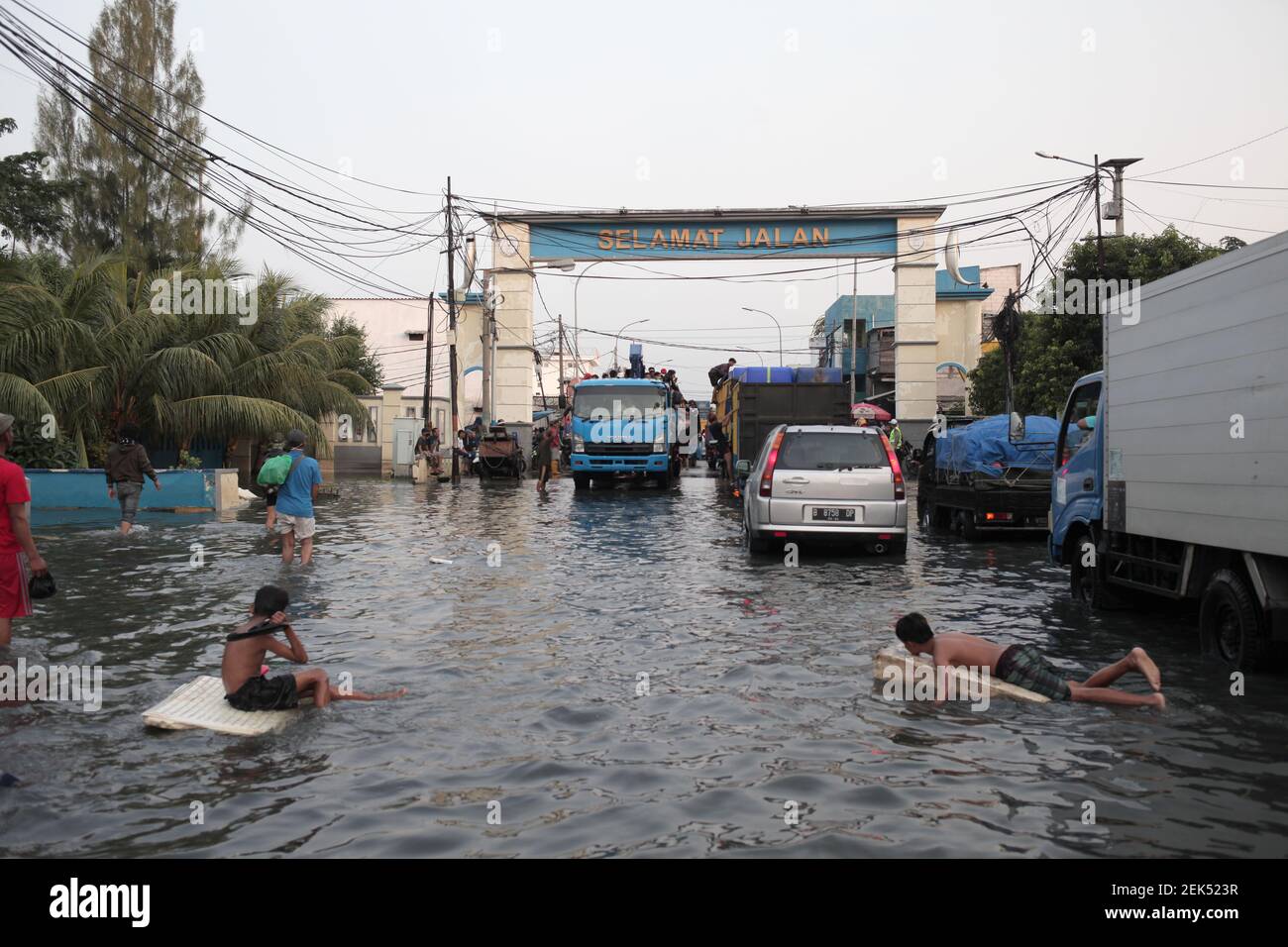 Children are seen playing in the flooded water while vehicles make ...