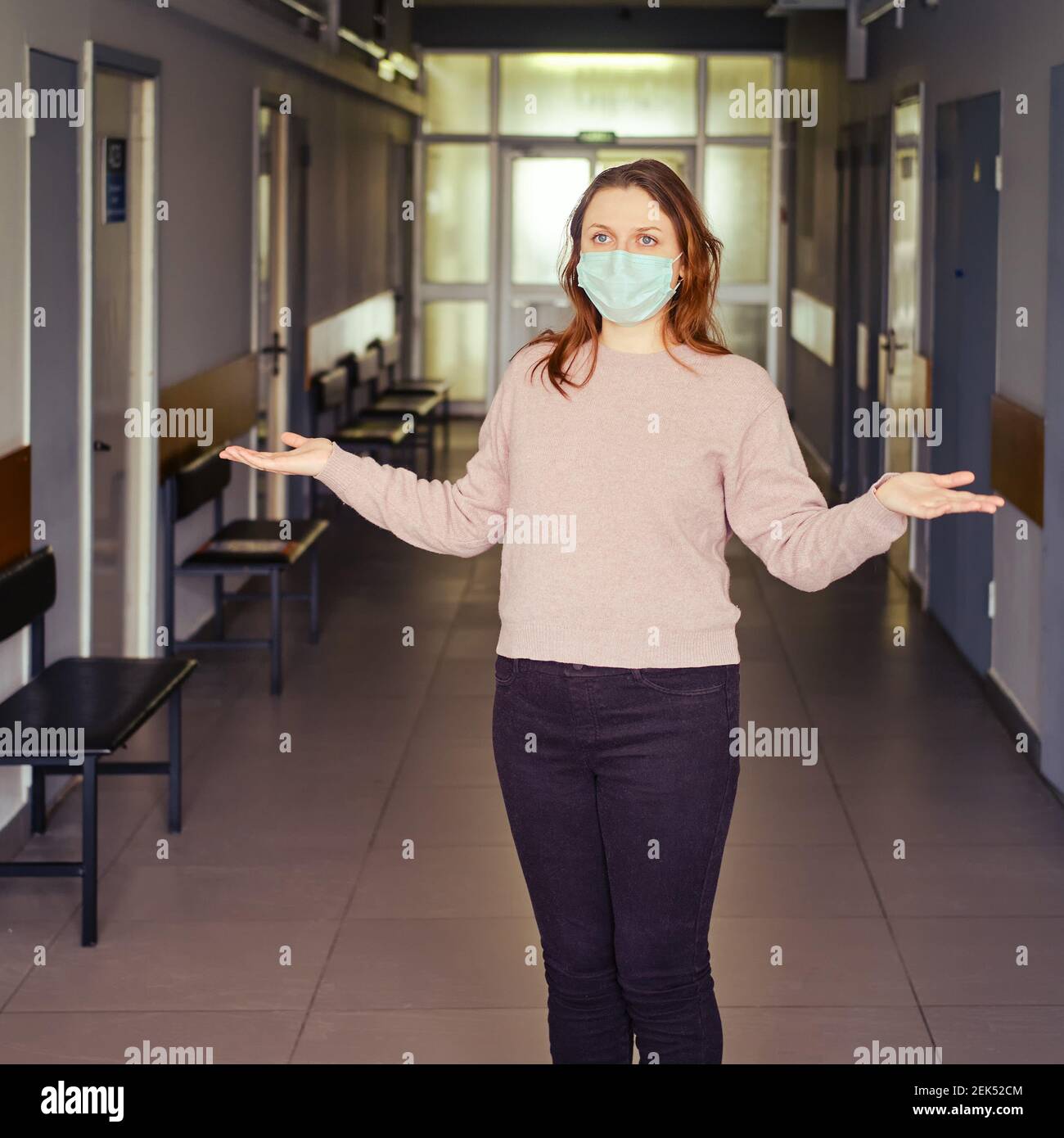 Adult woman stands with her arms spread out to the sides in the lobby ...