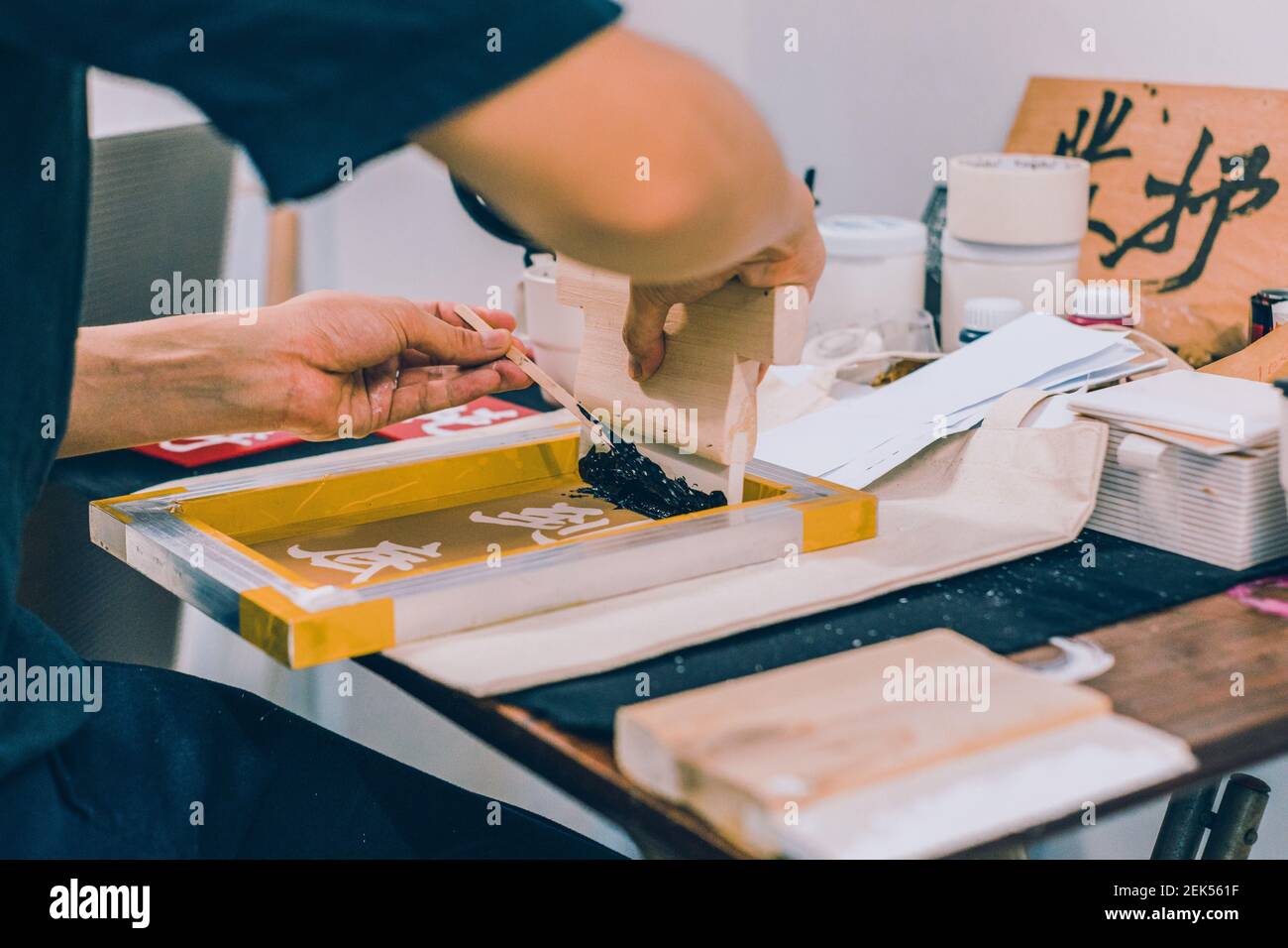 A participant applies a black ink onto calligraphy sift, to be ...
