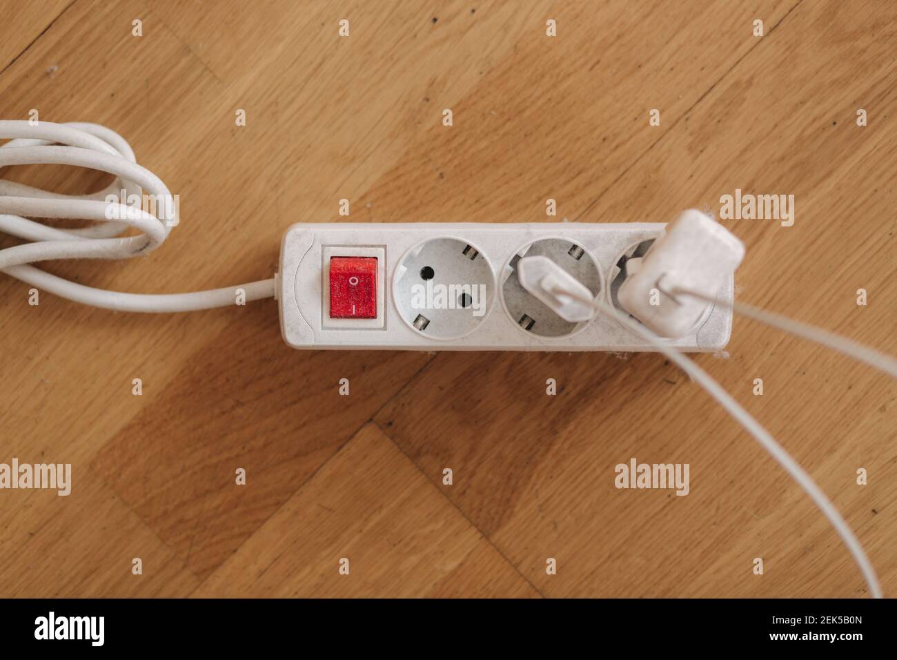 Dusty white extension cord at home. Dangerous inflammation. Top view ...
