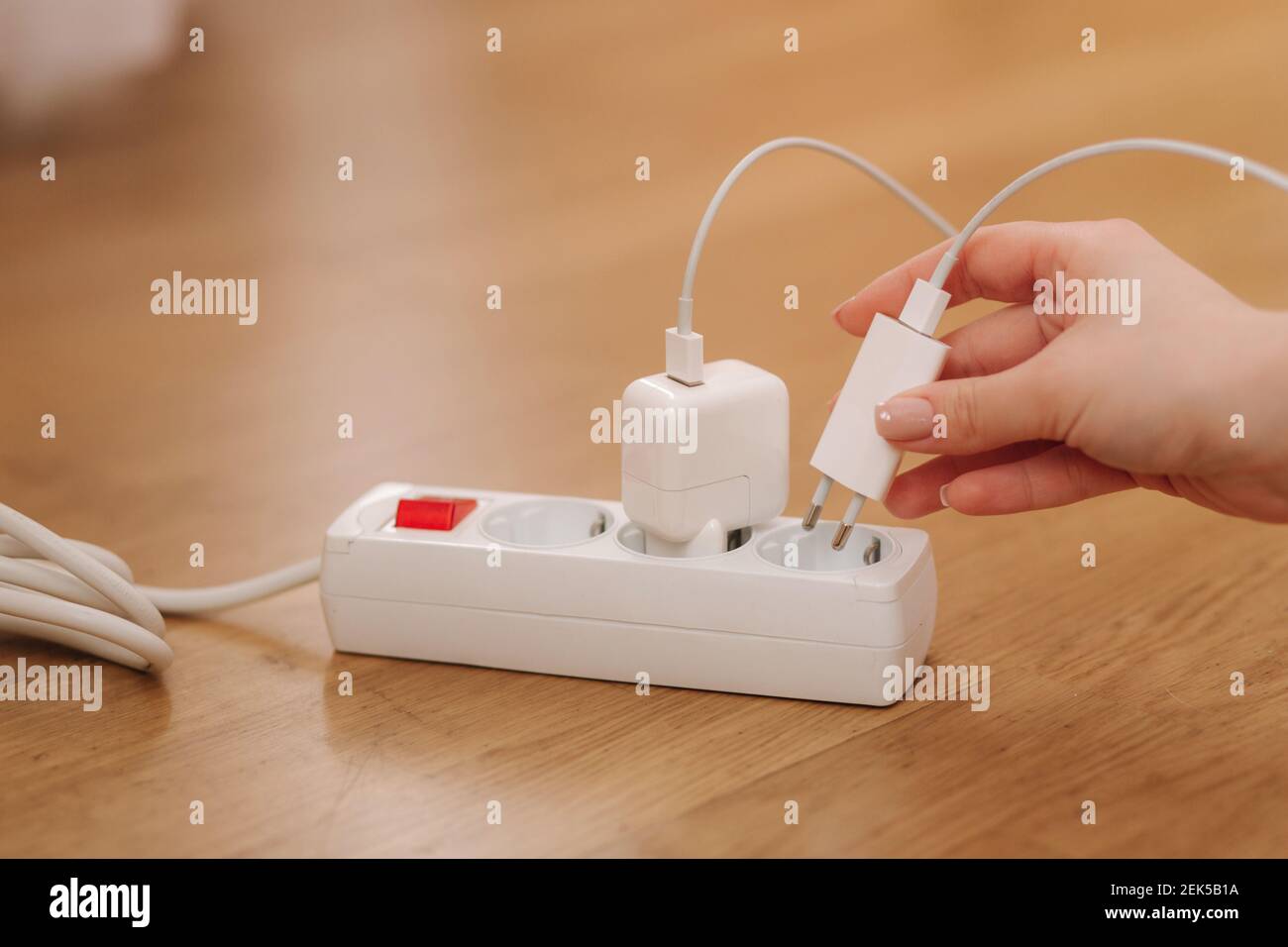 Woman pluging the wire into white extension cord. Close up of female ...