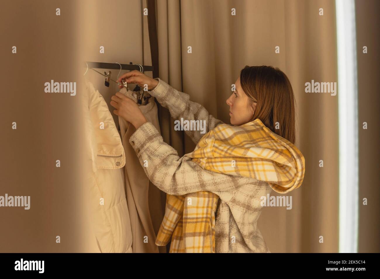 Woman trying on a coat in a fitting room of a clothing store Stock ...