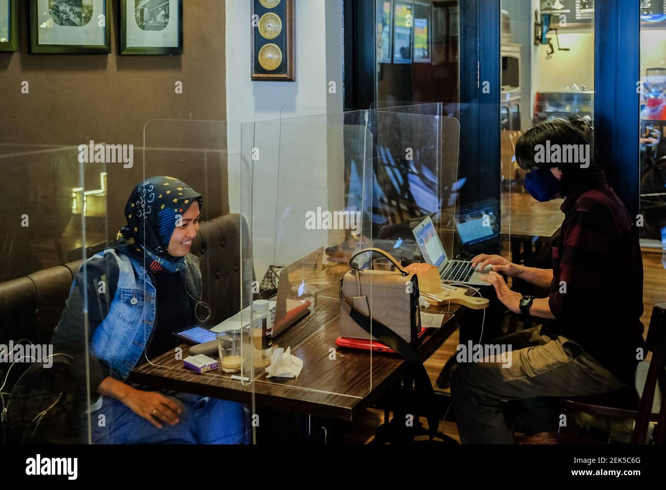 Customers dines in behind an acrylic separator at the Atjeh Connection ...