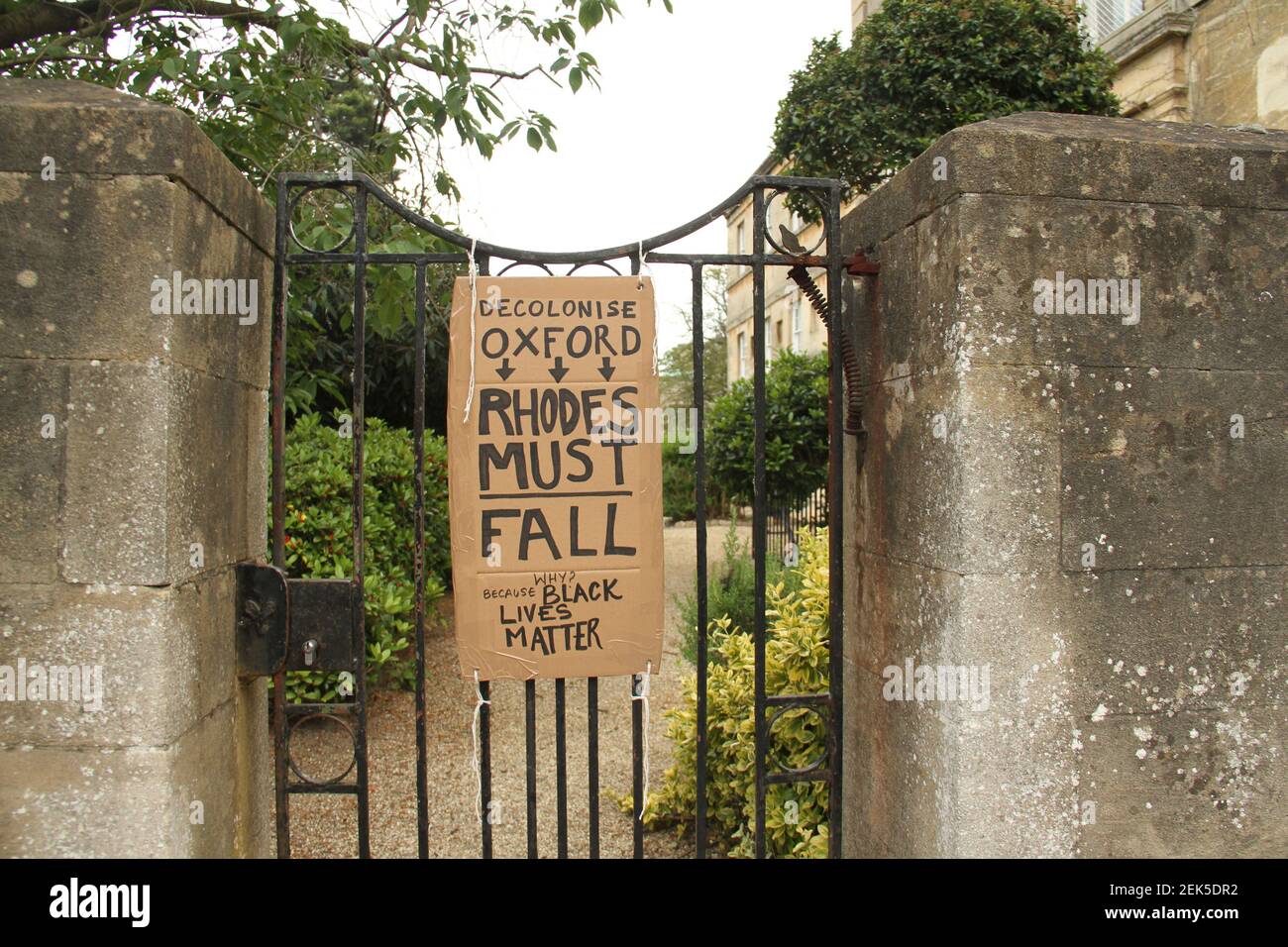 A Rhodes Must Fall placard hangs on a fence during the demonstration ...