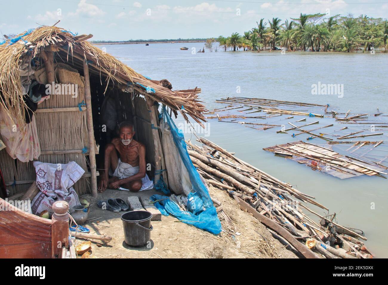 A man sits under a temporary shelter on the embankment during the ...