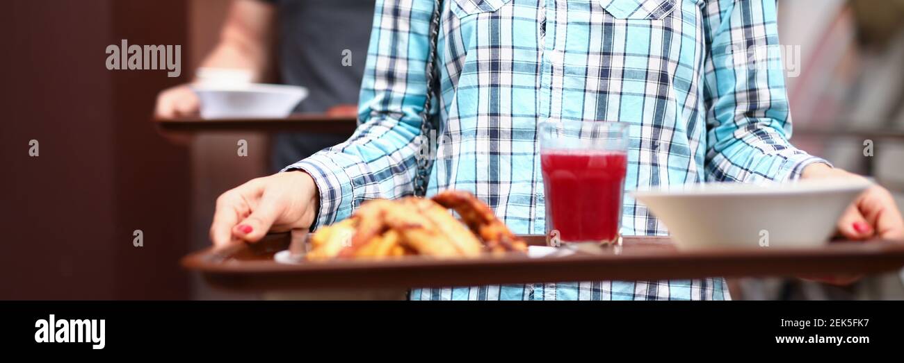 Woman stand in line with tray of food in her hands in a self-service ...