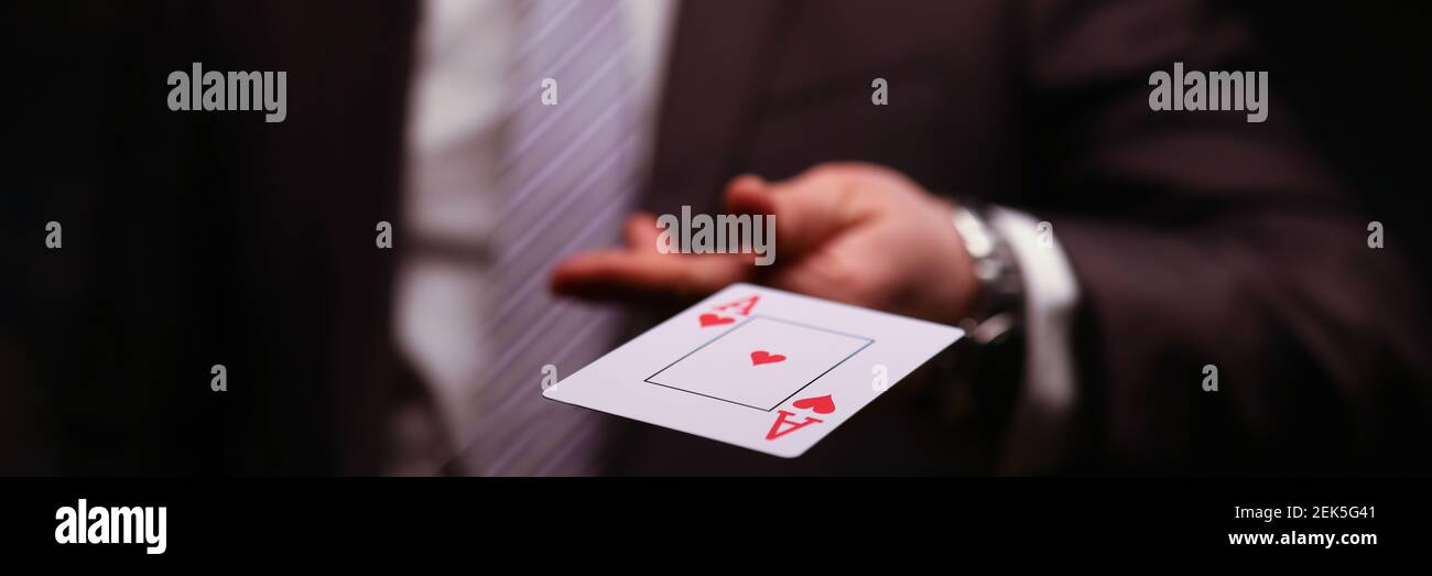 Man in business suit catche red ace playing card Stock Photo - Alamy