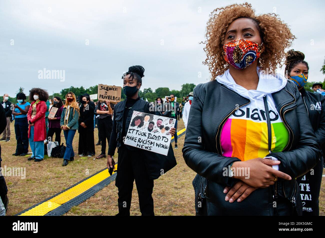A protester holding an anti racist placard while listening to speeches ...