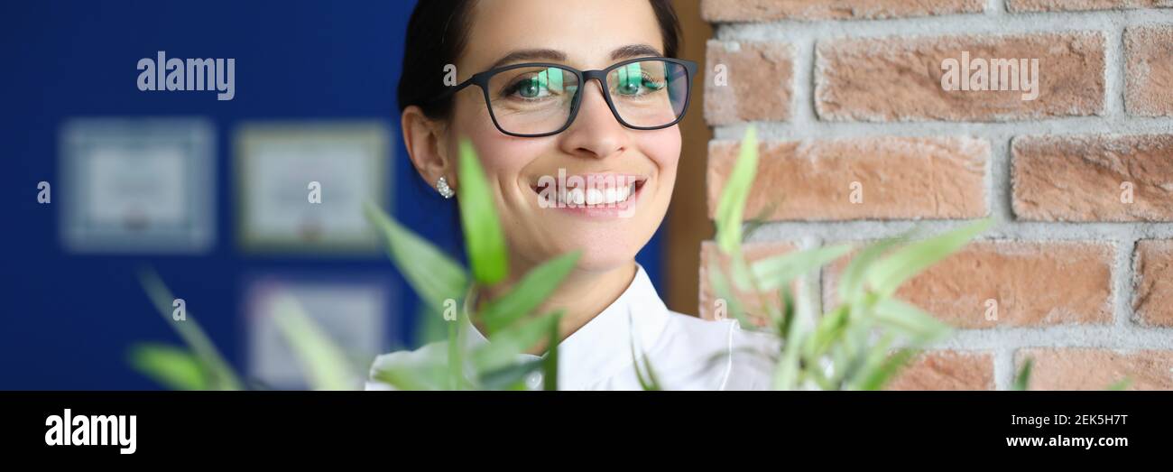 Happy office worker stand and smile at workplace with flower Stock ...