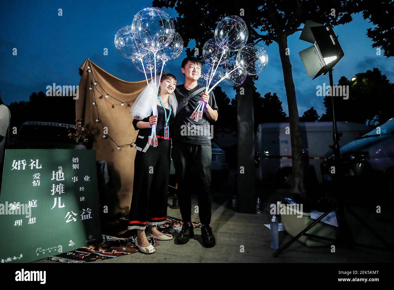 A couple takes photos at a street photo studio in Qingdao city, east ...