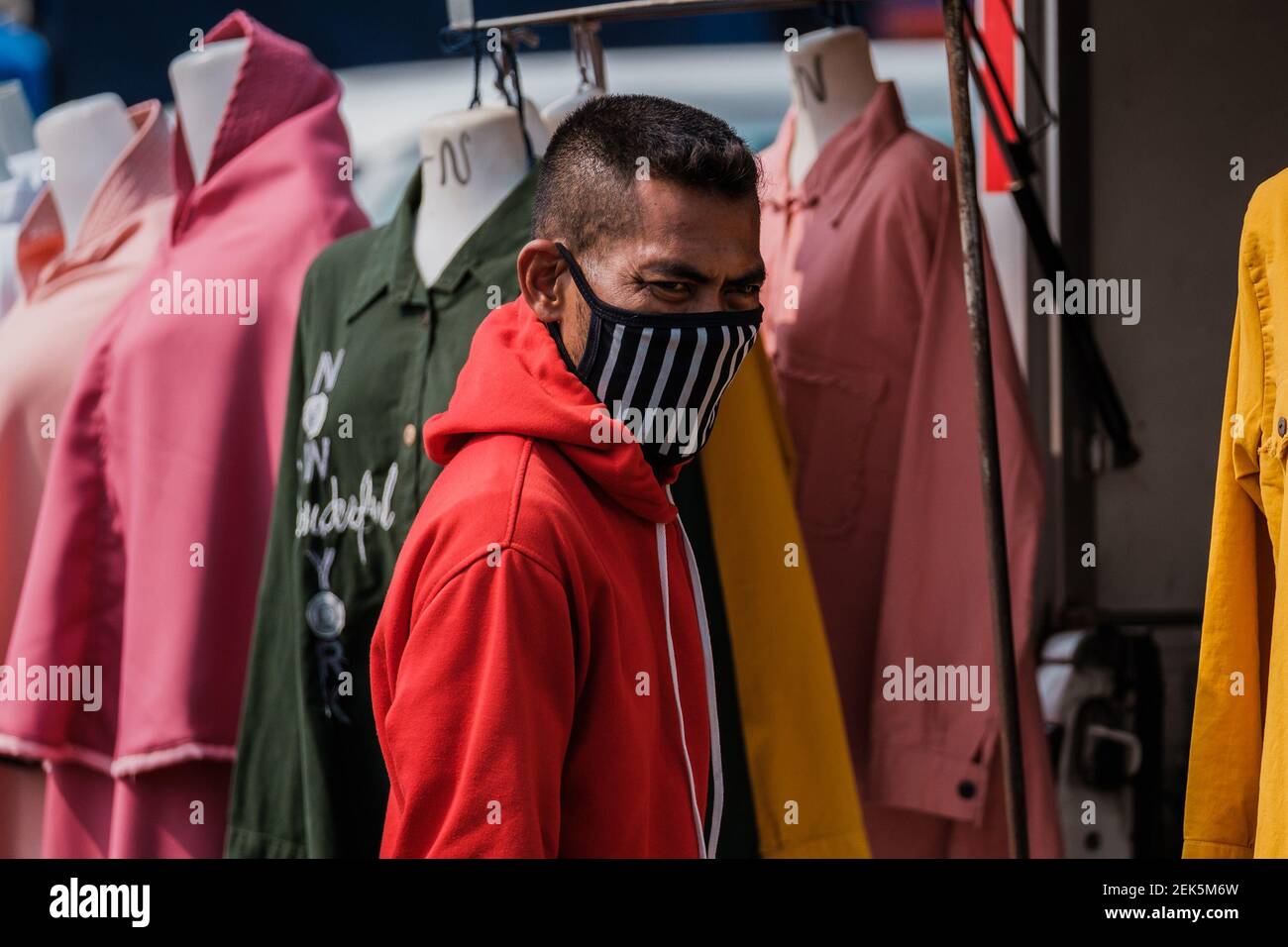 A street vendor wears face masks as a preventive measure, waiting for ...