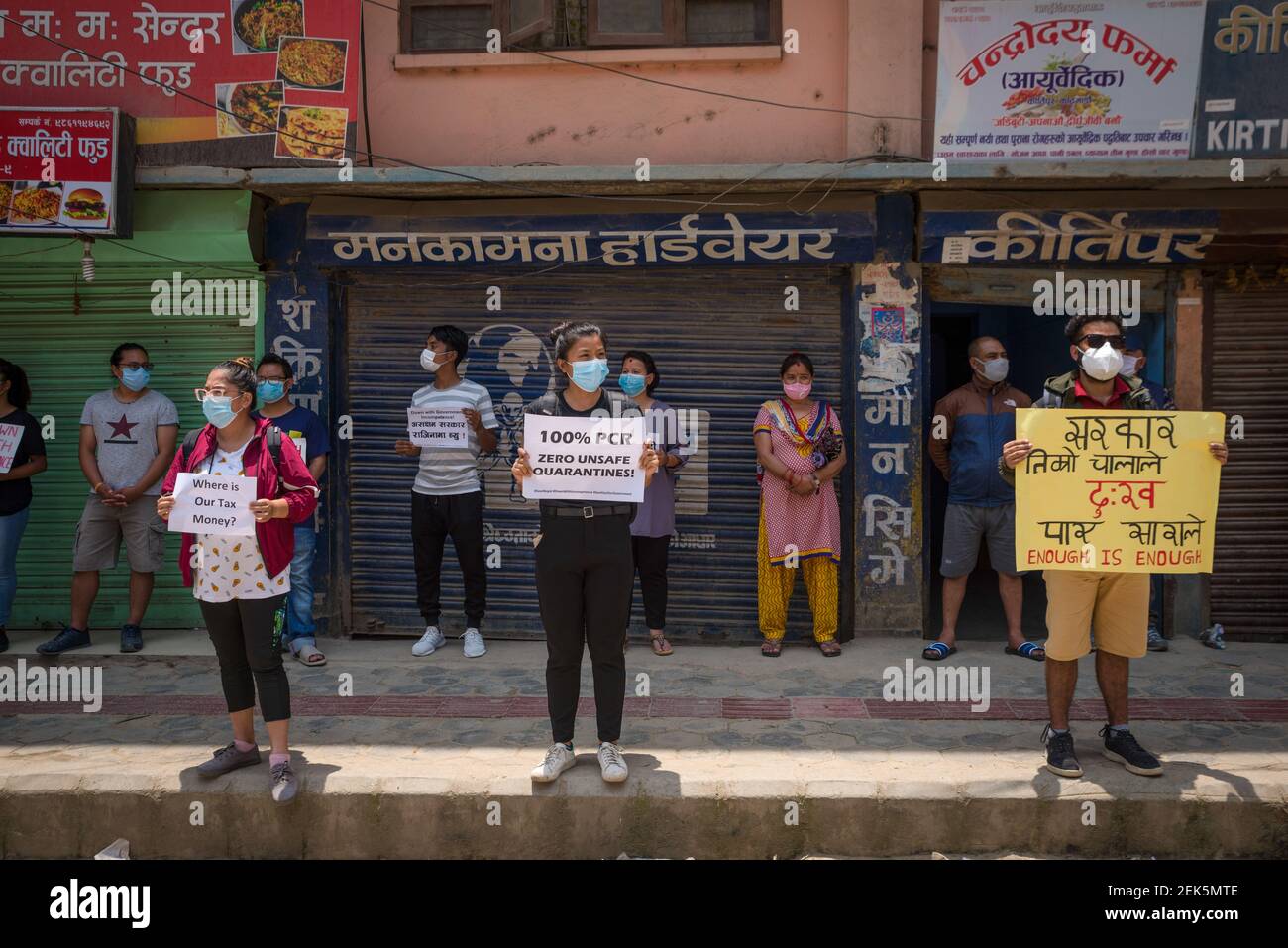 Protesters keep a safe distance while holding the placards during a ...