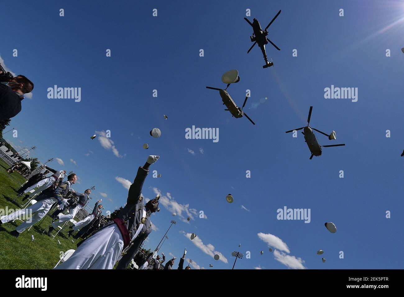 Military helicopters fly over cadets as they throw their hats in the ...