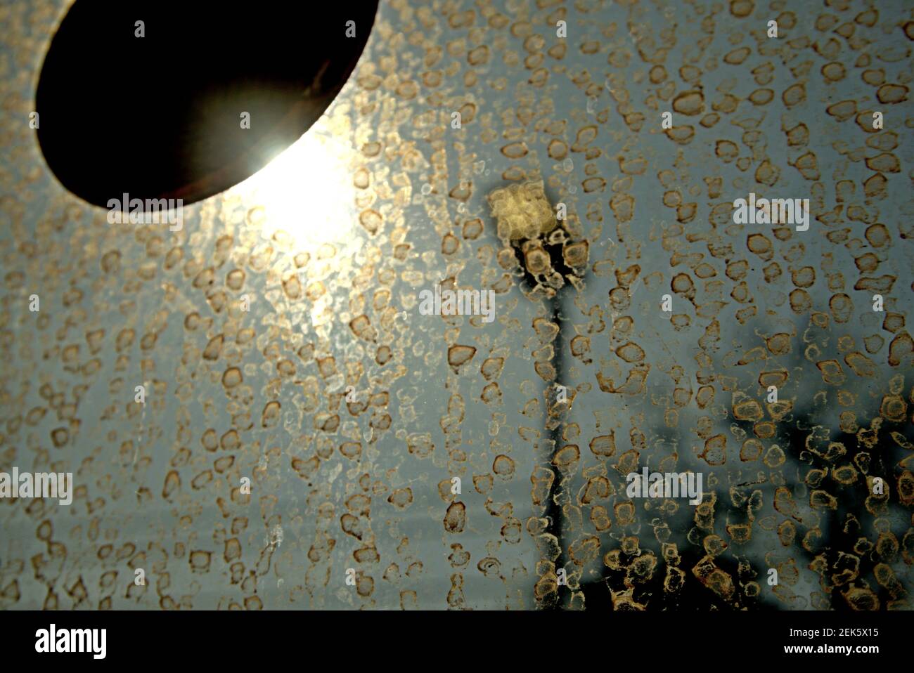 The sun behind a sticker on a dirty train window creates the effect of ...