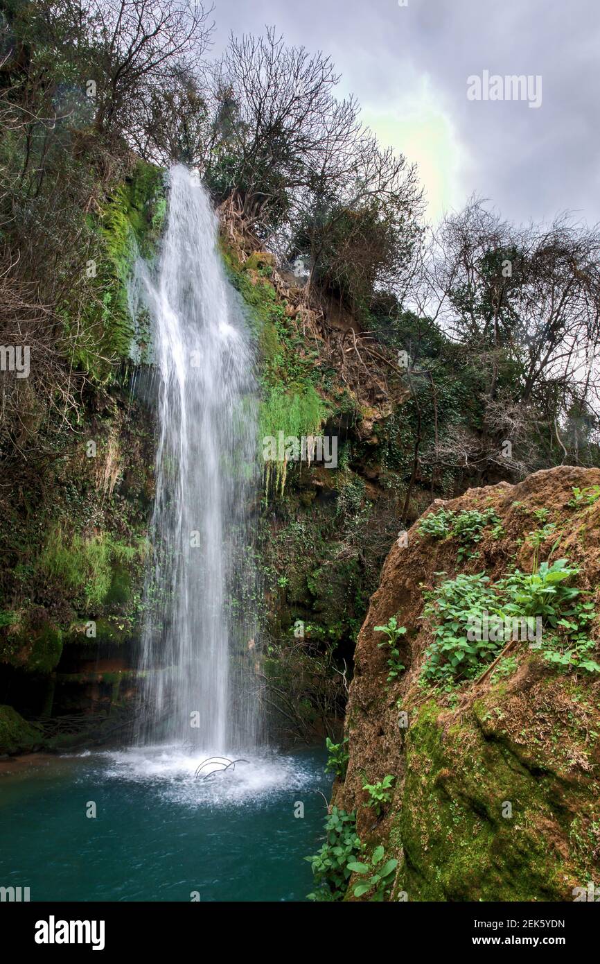 A large beautiful waterfall in a forest with blue water and trees Stock ...